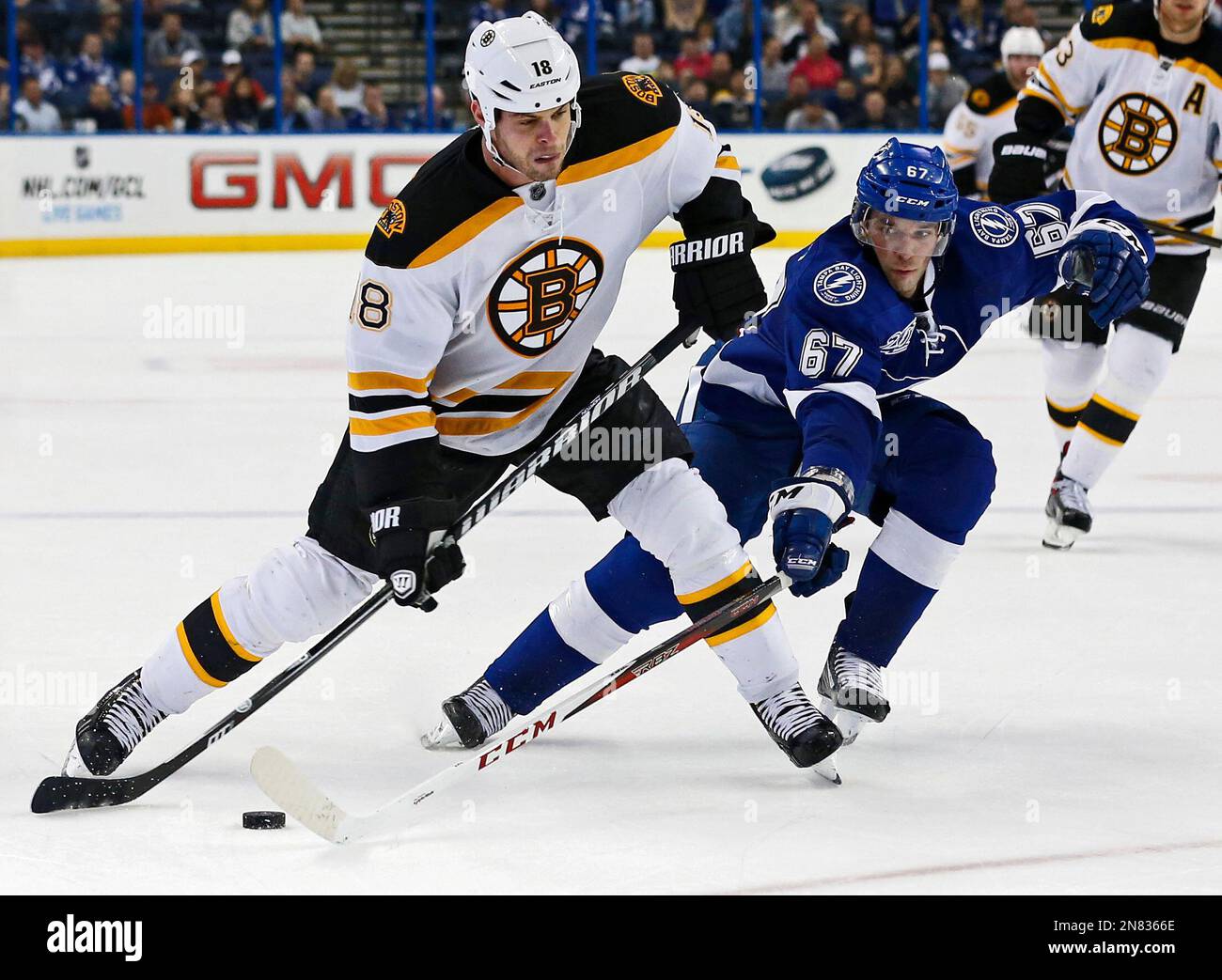 Boston Bruins' Nathan Horton, left, shoots ahead of a check by Tampa ...