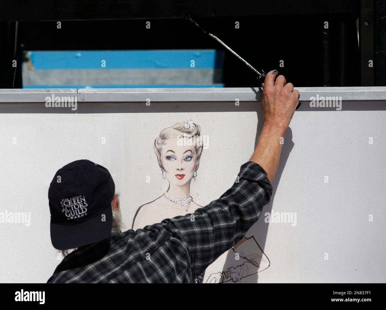 Sam Costa paints a rail in the red carpet arrival area outside the ...
