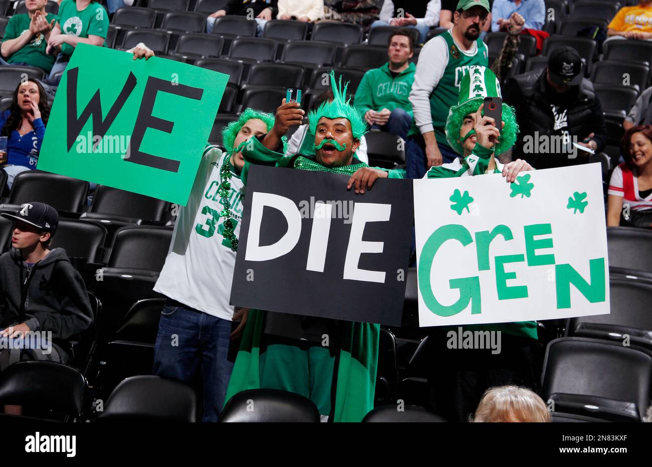 Boston Celtics fans hold placards as their team takes the court to face ...
