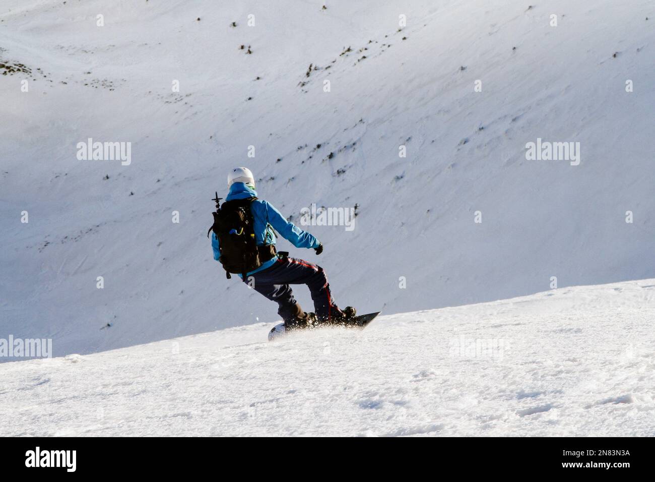 Freerider snowboarder going down the slope, back view. Adventures ...