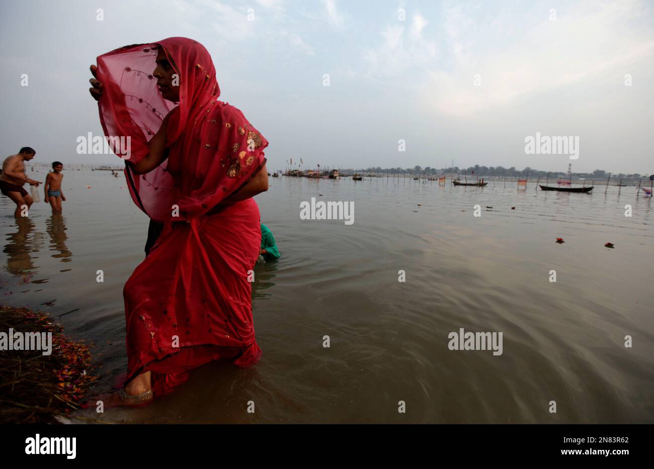 An Indian Hindu devotee returns to the shore after performing rituals ...