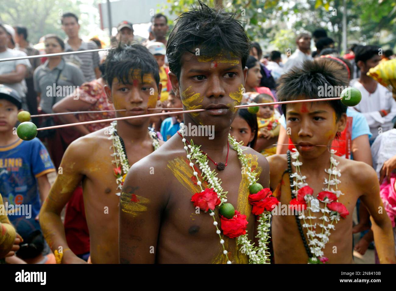 Myanmar Hindu devotees stand with their mouths pierced while waiting to ...