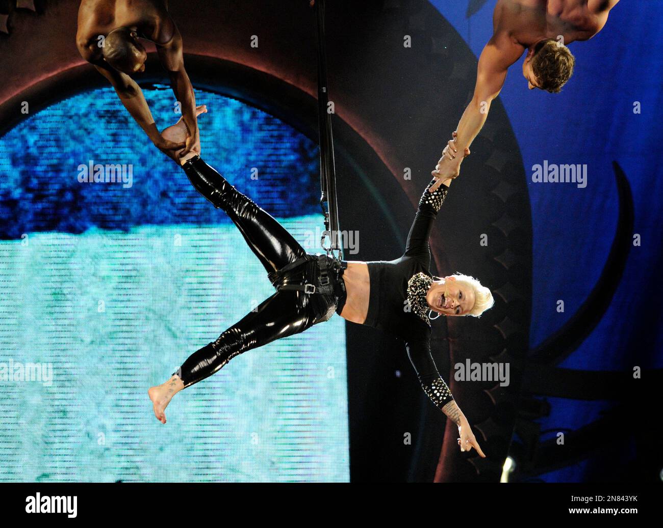 Pink is held aloft by backup dancers as she performs in mid-air during ...