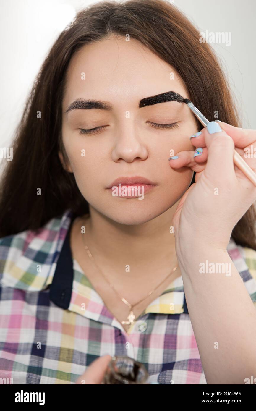 Beautician dying eyebrows with henna Stock Photo - Alamy