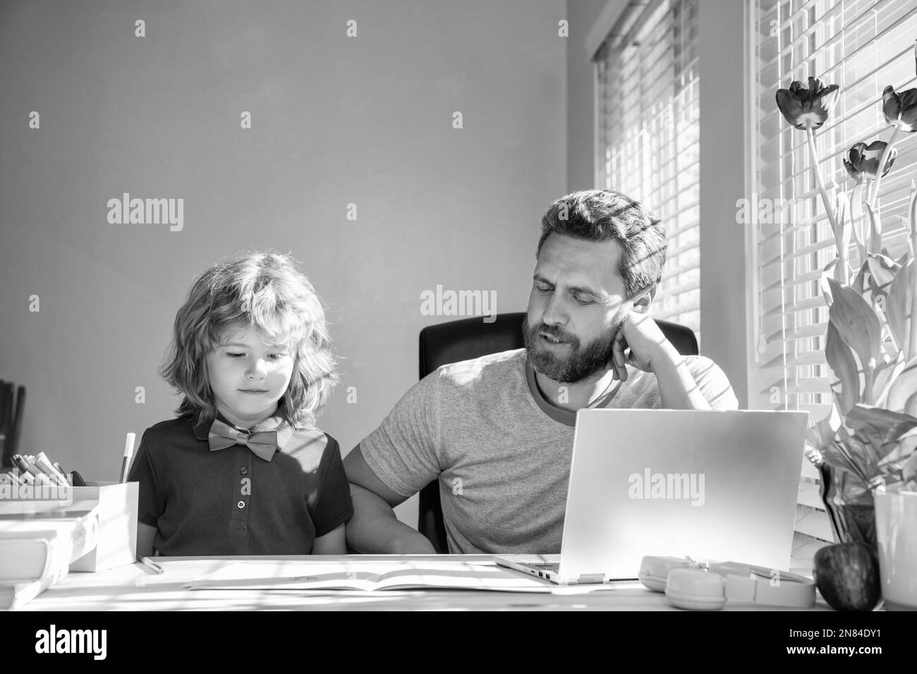 back to school. concentrated father and son use computer at home. family and parenthood blog ...
