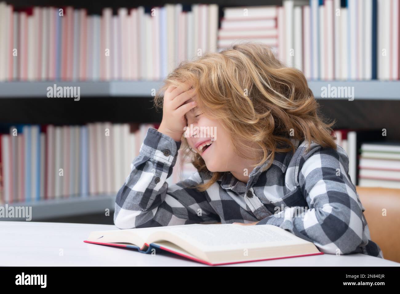 Kid reading book in a book store or library Stock Photo - Alamy