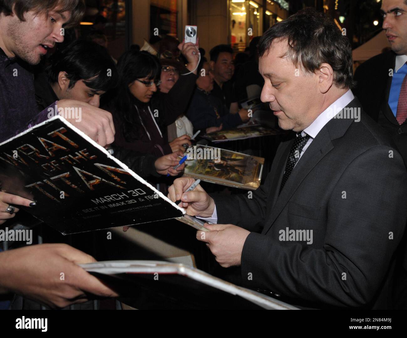 Sam Raimi signs autographs as he arrives at the world premiere of "Oz ...