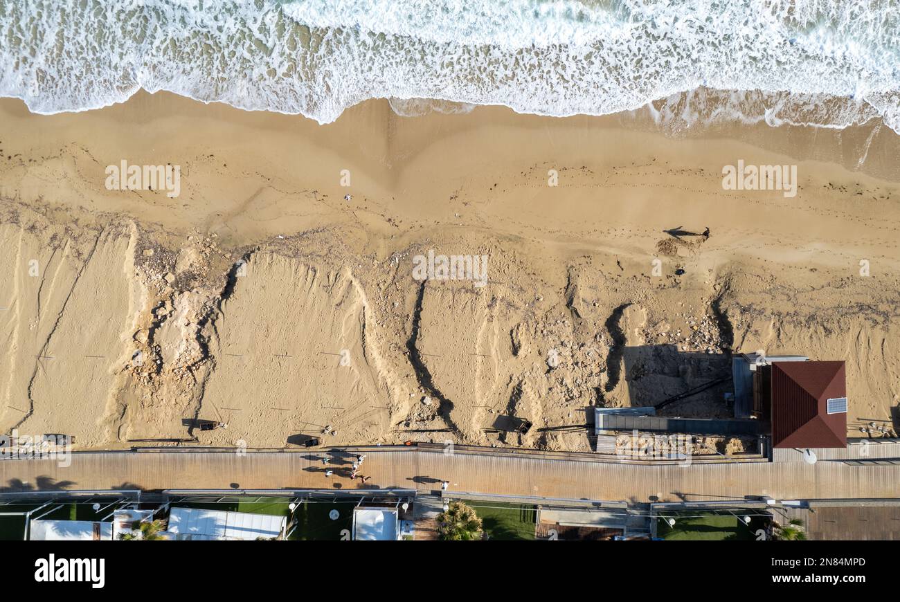 Aerial view of ocean waves breaking on a sandy beach. Beach erosion ...