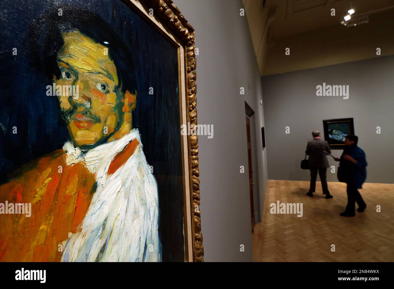 Members of the press walk through a gallery in front of an oil on ...
