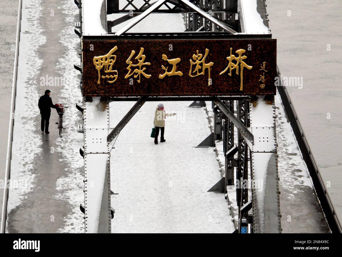 Visitors walk on a Yalu bridge destroyed during Korean War on the Yalu ...