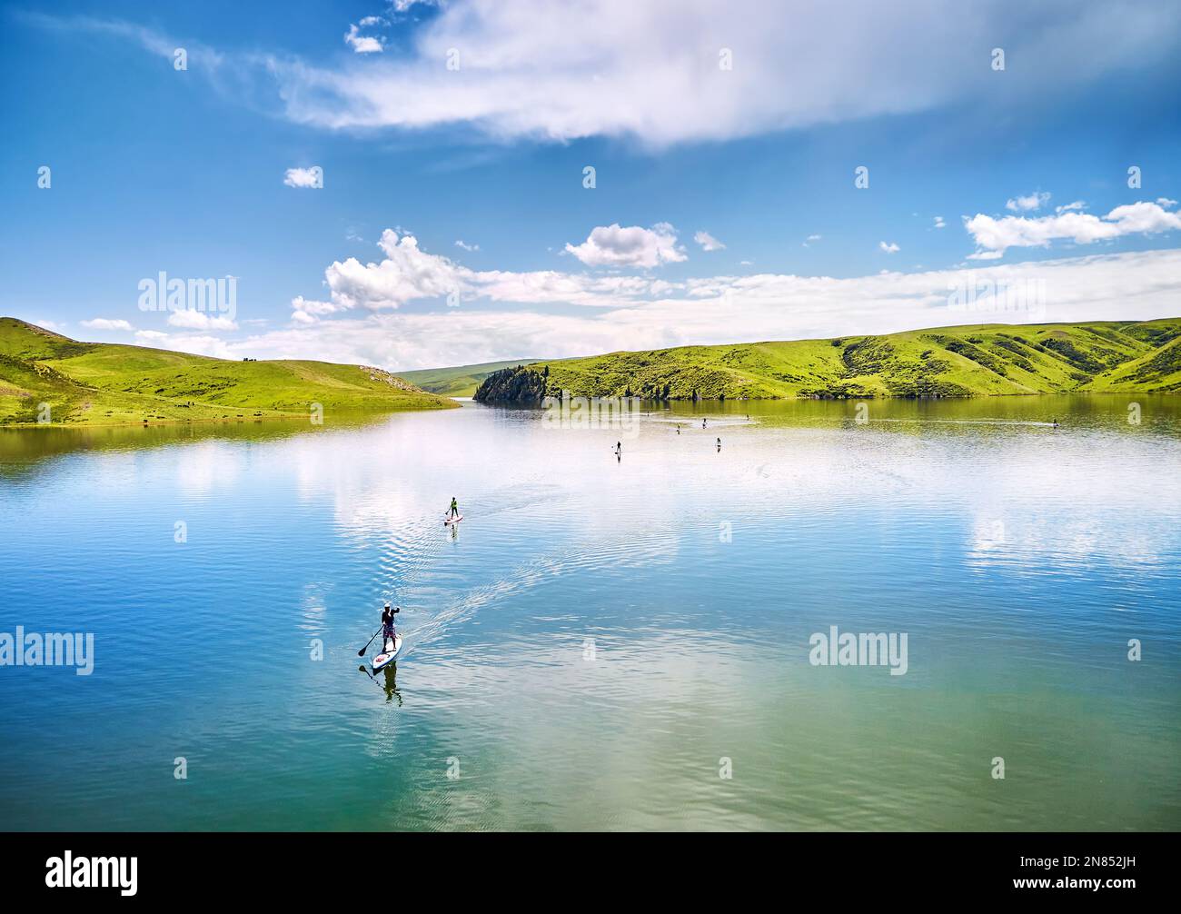 Top down aerial drone shot of group of people at stand up paddle boards ...