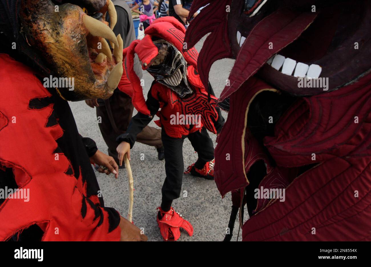 A boy disguised as a devil poses for photos before participating in a ...