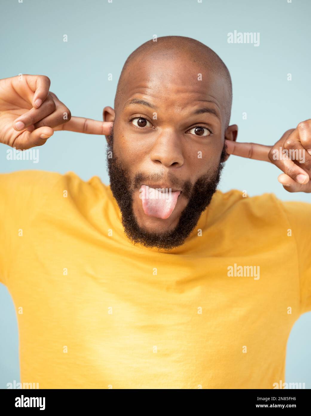 Comic, playful and portrait of a black man with a funny face isolated ...