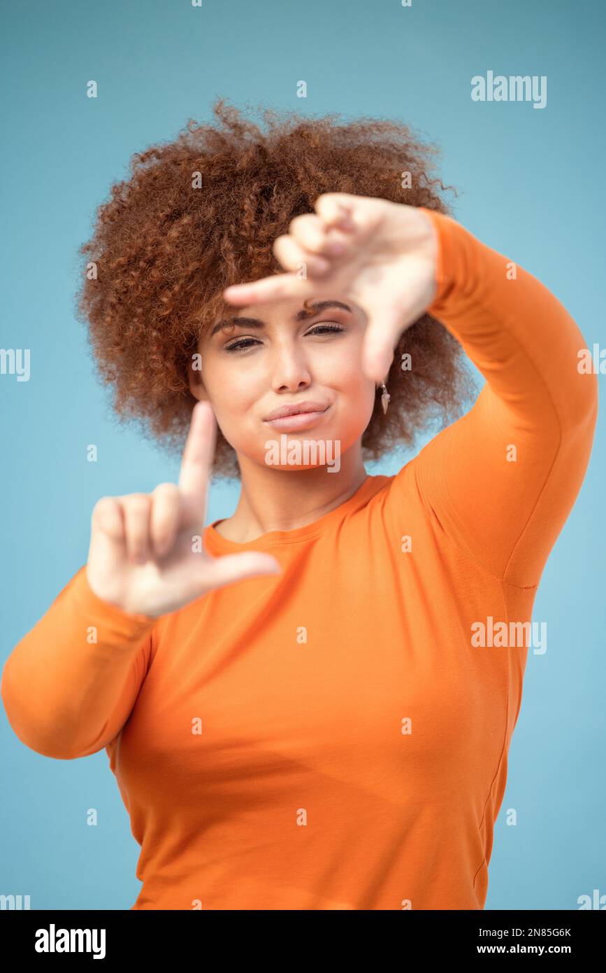 Hands, frame and portrait of black woman on blue background for profile ...