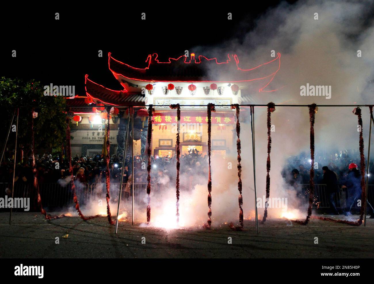 People light firecrackers in celebration of the Chinese and Vietnamese ...