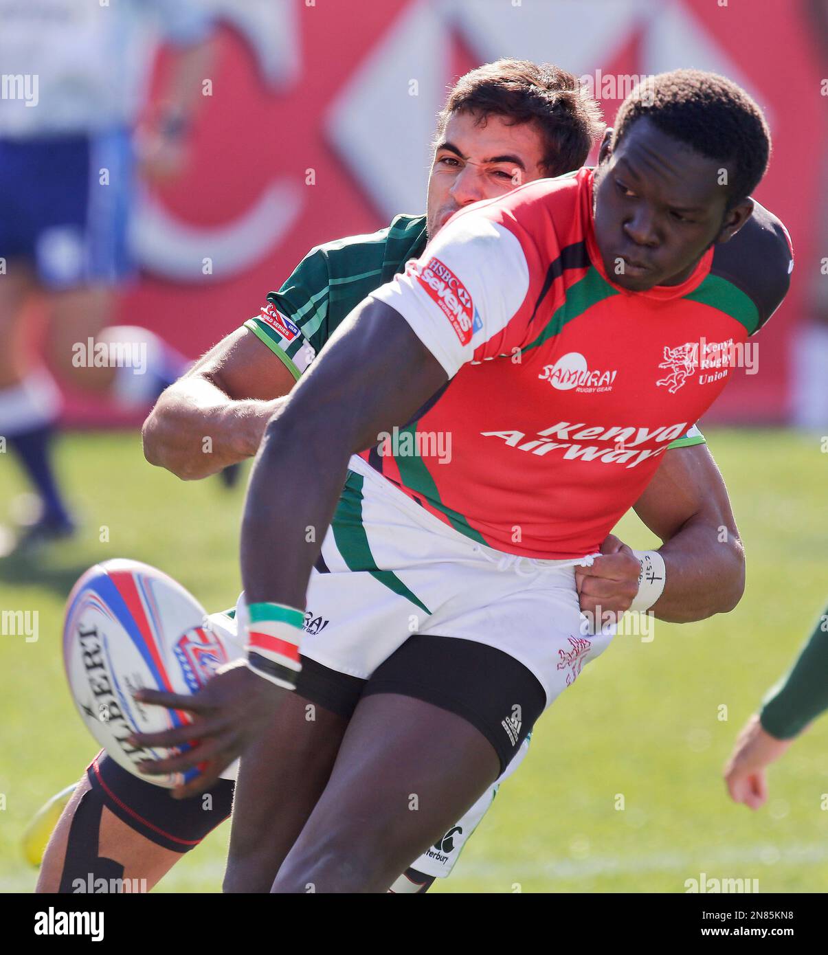 Kenya's Andrew Amonde, right, makes a lateral pass as he is hit by ...