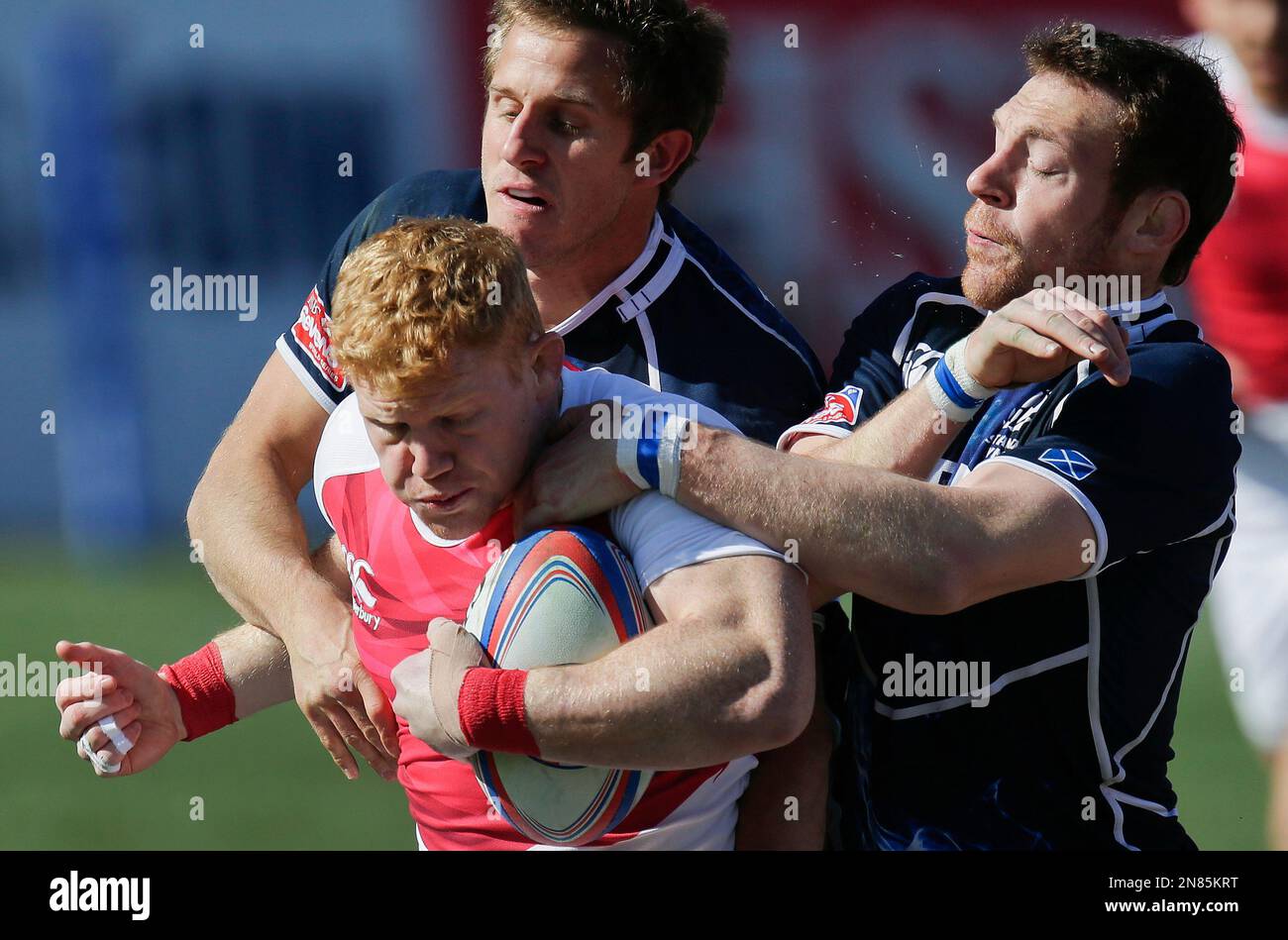 England's John Brake, center, gets wrapped up by Scotland's Mark ...