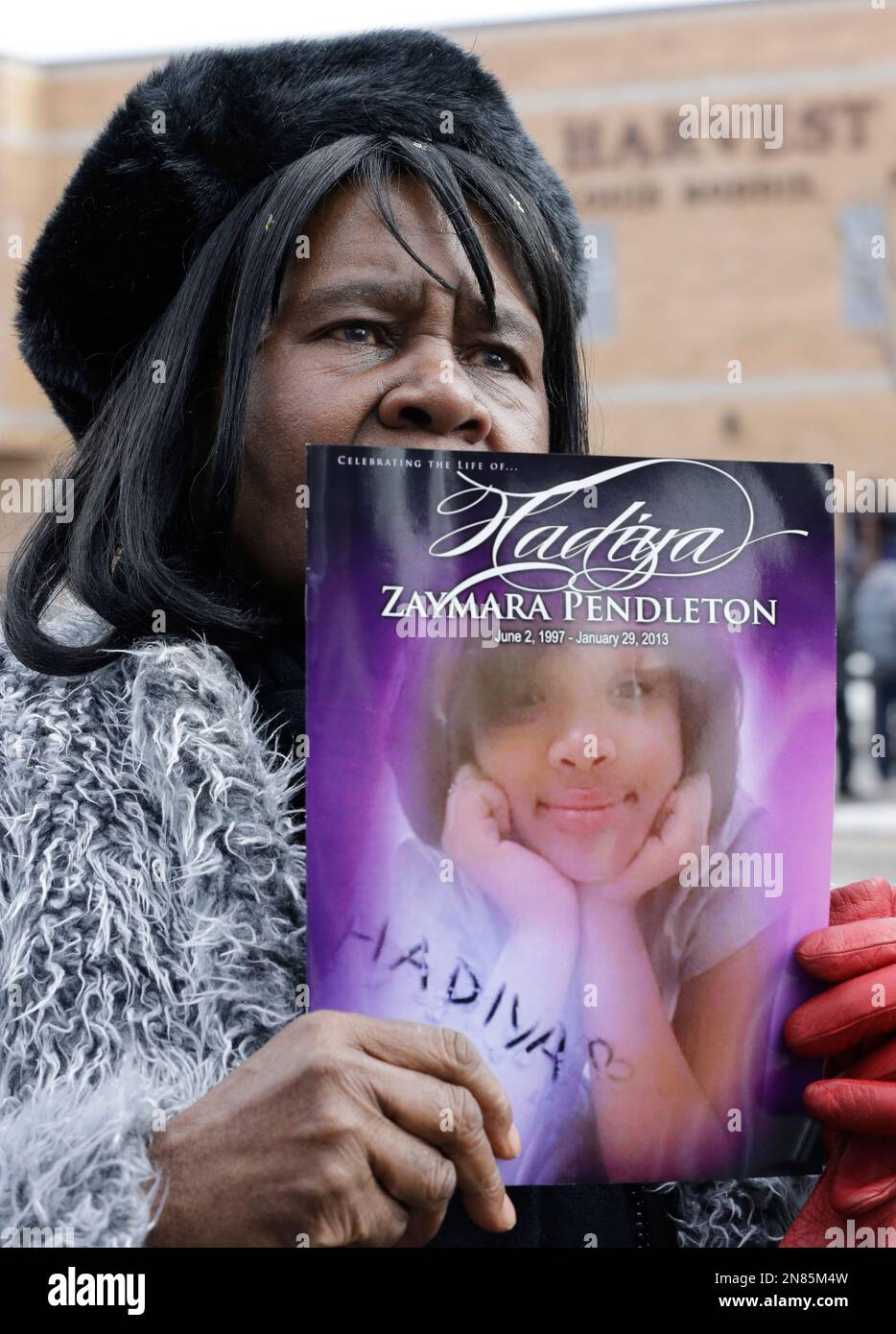 A mourner holds up a program for the funeral of Hadiya Pendleton ...