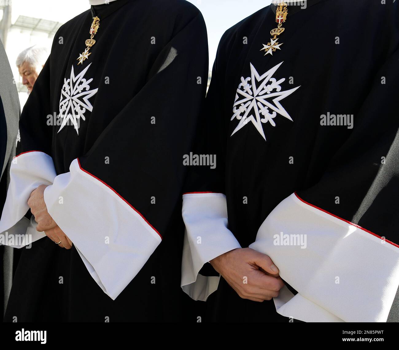 Members of the Knights of Malta wear a dark cloak with a white, eight ...