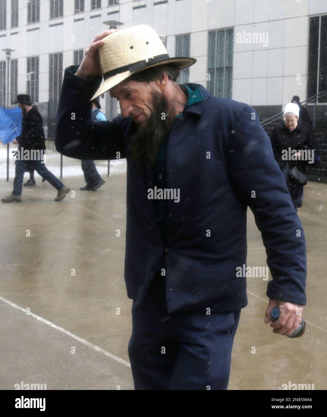 An Amish man holds onto his hat as he leaves the U.S. Federal ...