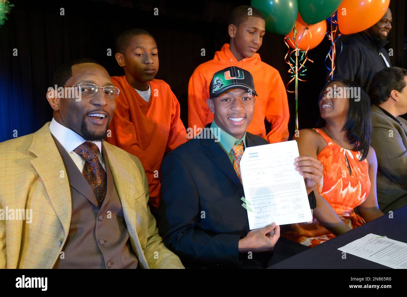 Ray Lewis III, center, shows his national letter-of-intent form as his ...