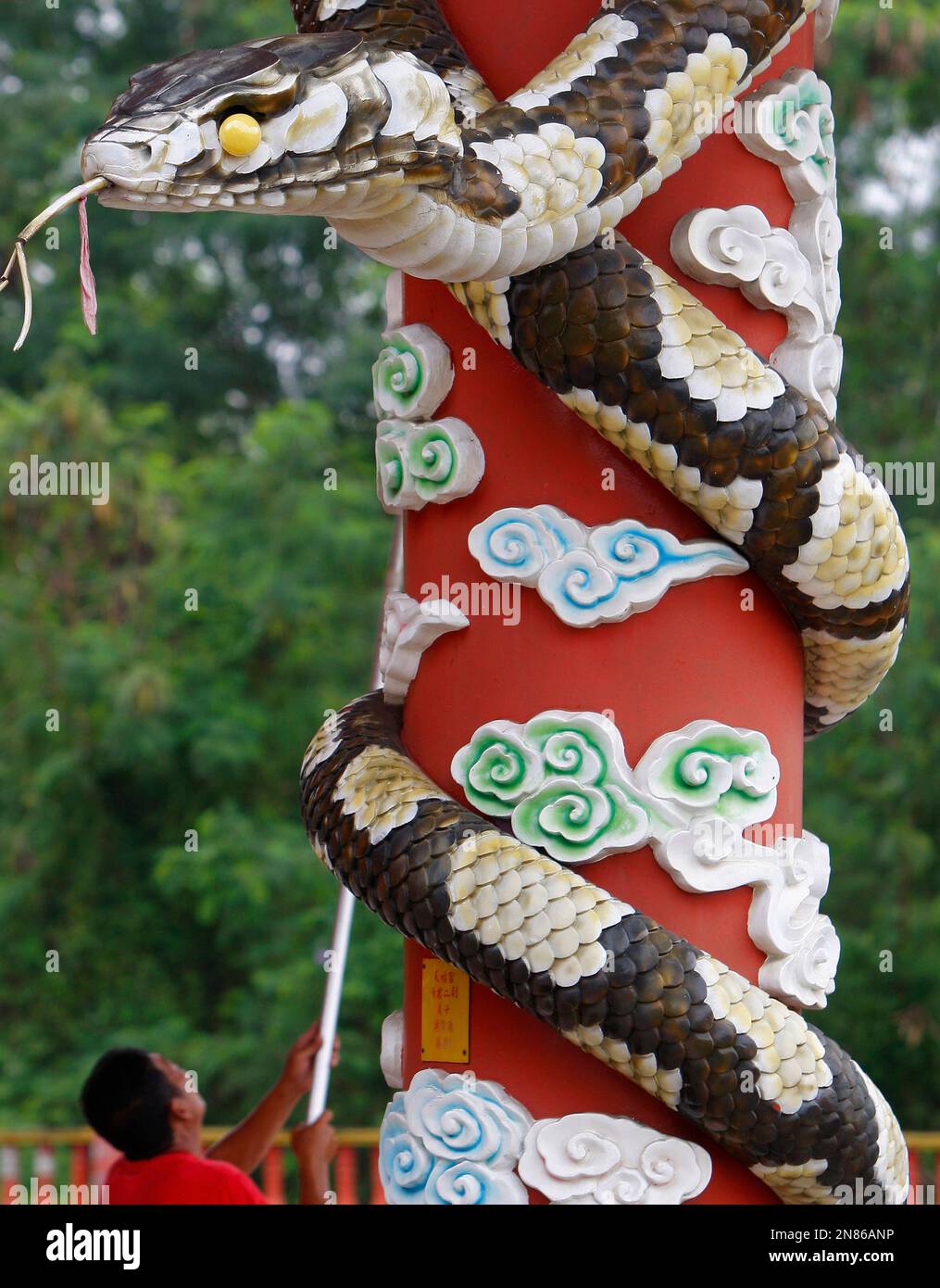 An ethnic Chinese Malaysian paints a ceiling of Thean Hock Keong temple ...