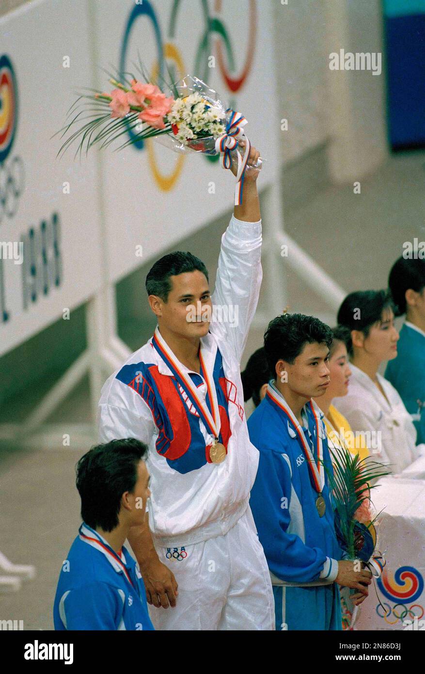 U.S. diver Greg Louganis stands wearing an Olympic gold medal after ...