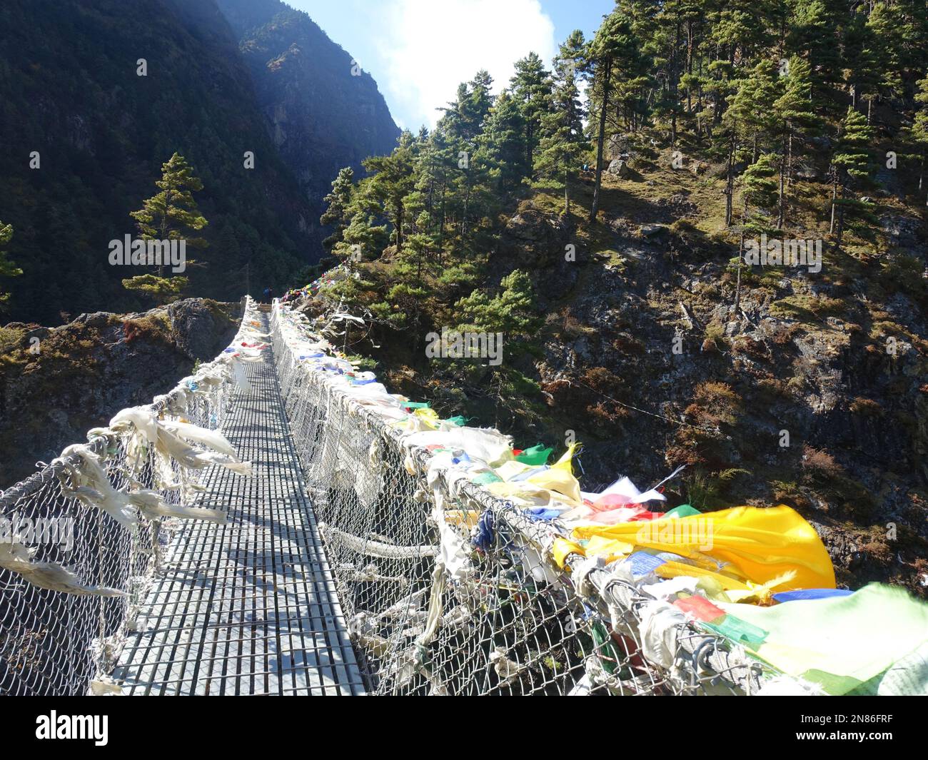 A suspension bridge with colorful flags in the Himalayas Stock Photo ...