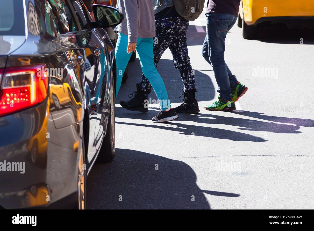 young people crossing a street in NYC between standing cars Stock Photo ...