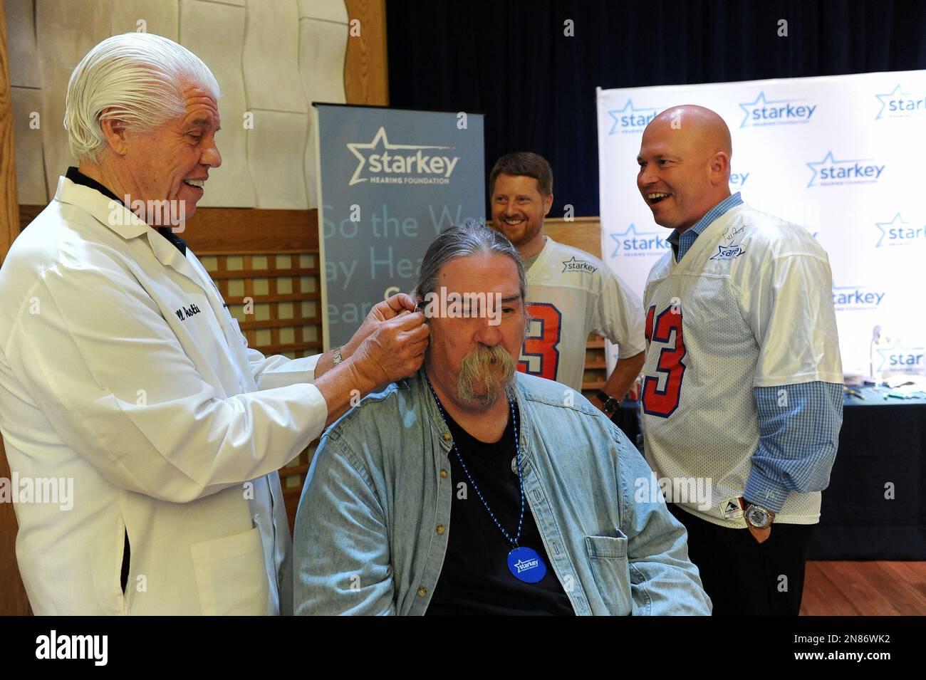 Bill Austin, founder of Starkey Hearing Foundation fits musician Owen ...
