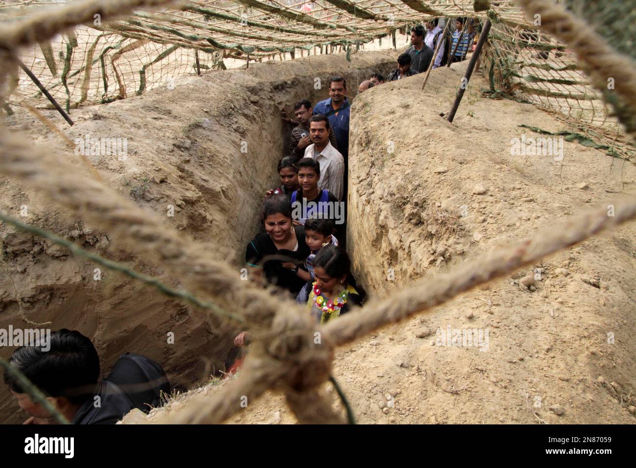 Indians walk through a trench leading to an underground bunker during a ...