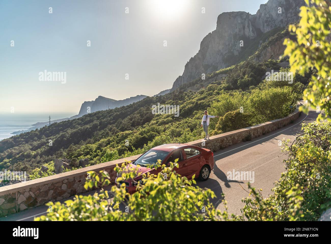 Mountain road woman. She walks along a parapet road in the middle of a ...