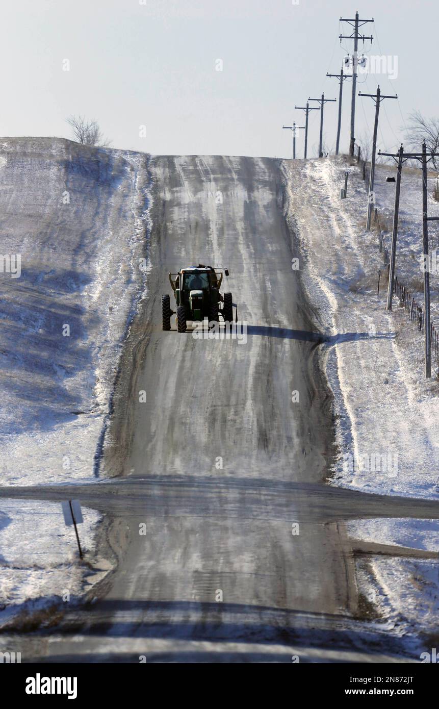 Bill Conley drives a tractor to feed cattle on his farm near Delia, Kan ...