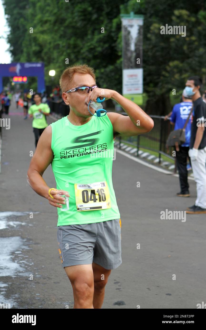 a male marathon runner who runs while drinking water Stock Photo - Alamy