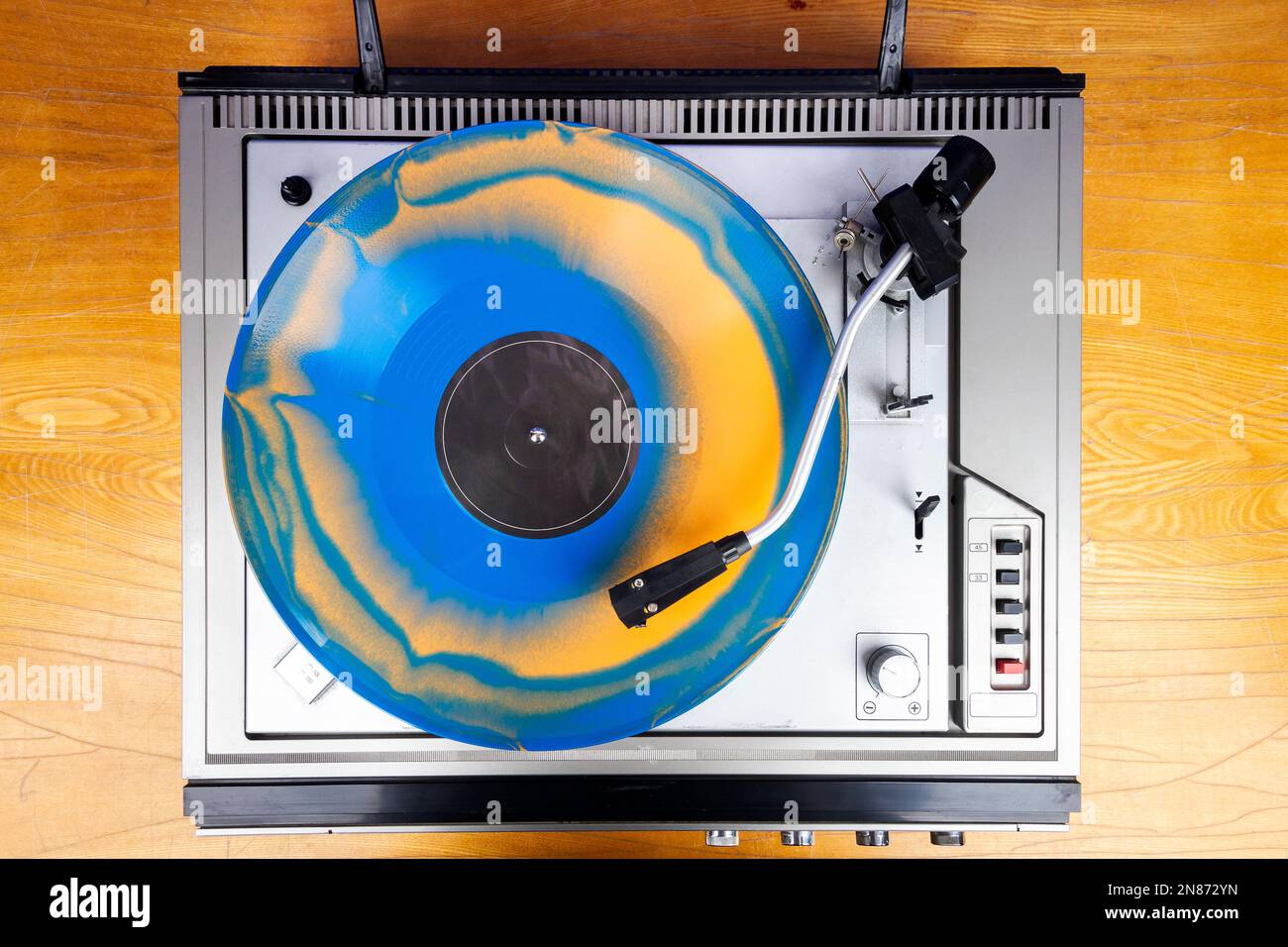 Vintage turntable vinyl record player with blue and orange vinyl on a ...