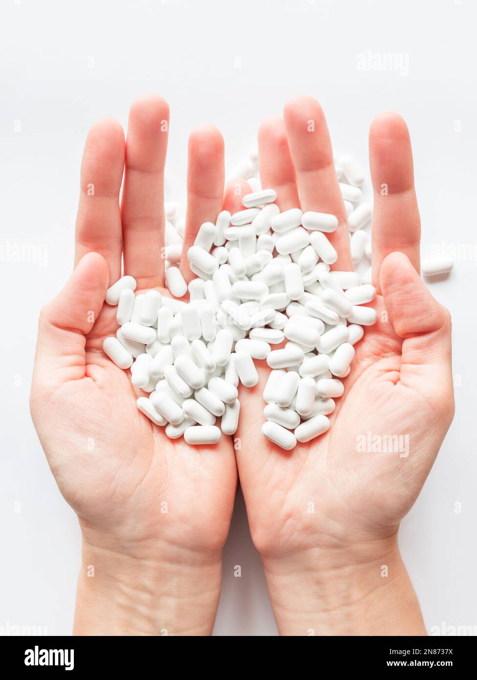 Palm hands full of white scattering pills. Woman gripes hand with ...