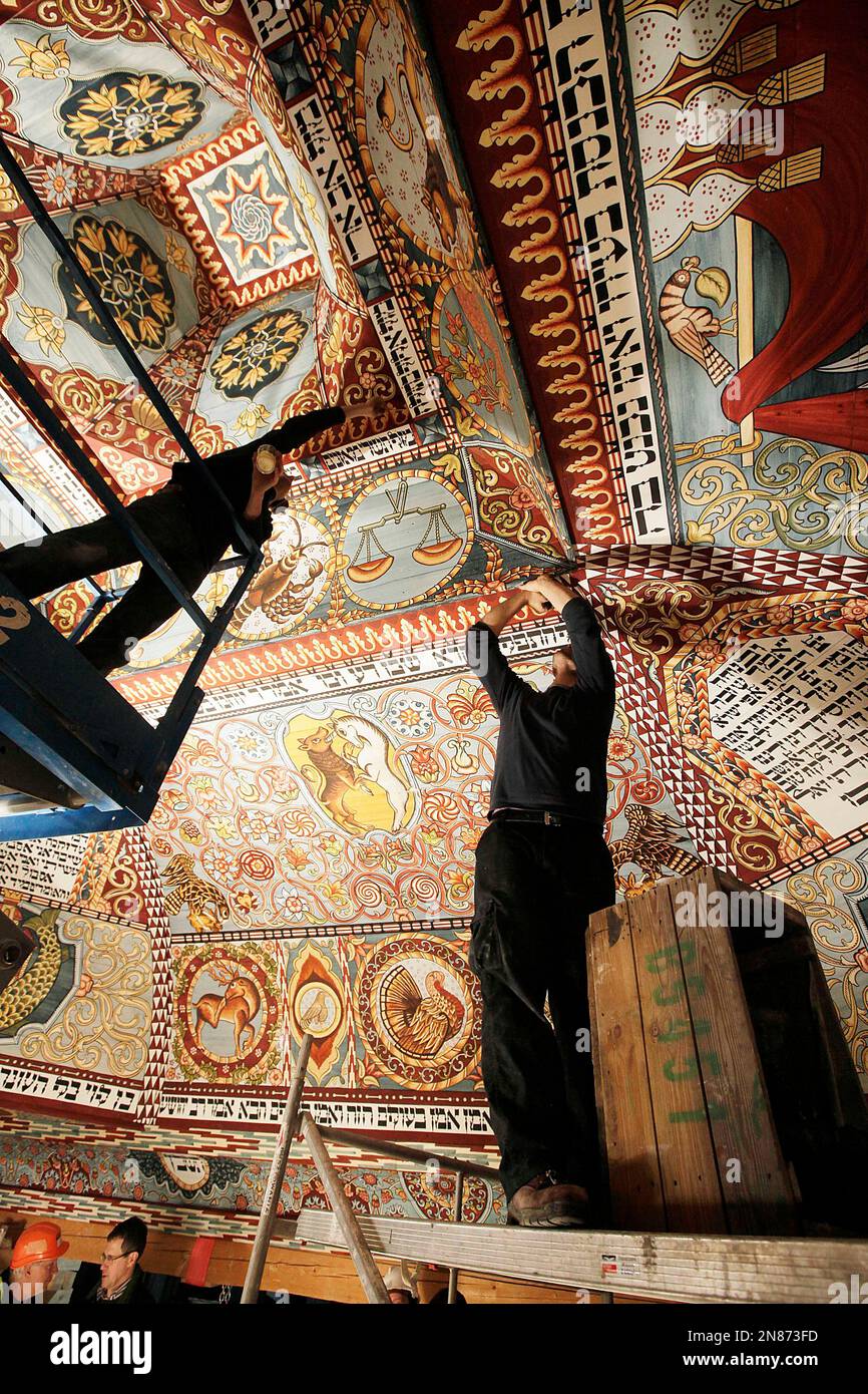 Volunteers paint details of a reconstructed 18th century synagogue roof ...
