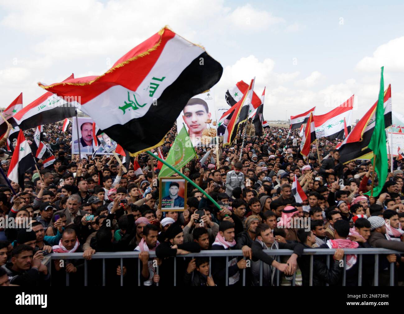 Iraqis chant anti-government slogans as they wave national flags and ...