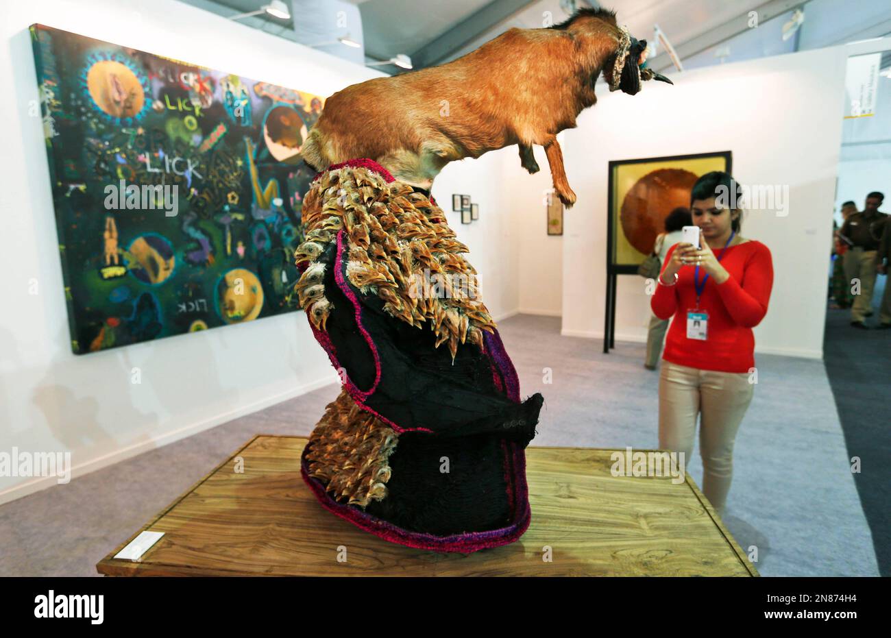 An Indian woman takes photos of an art work by Shine Shivan at the 5th ...