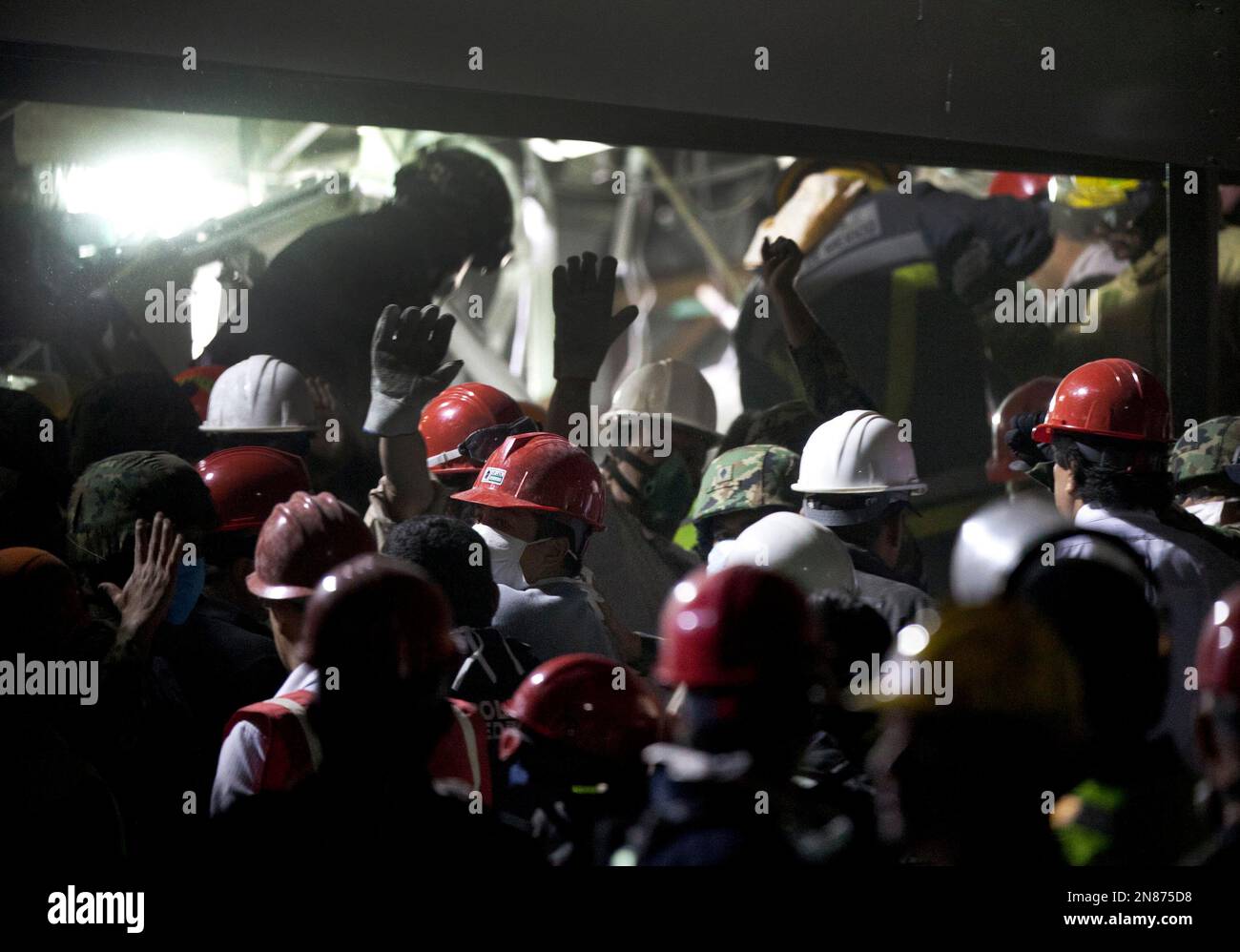 Rescue workers, firefighters and military search for survivors at the ...