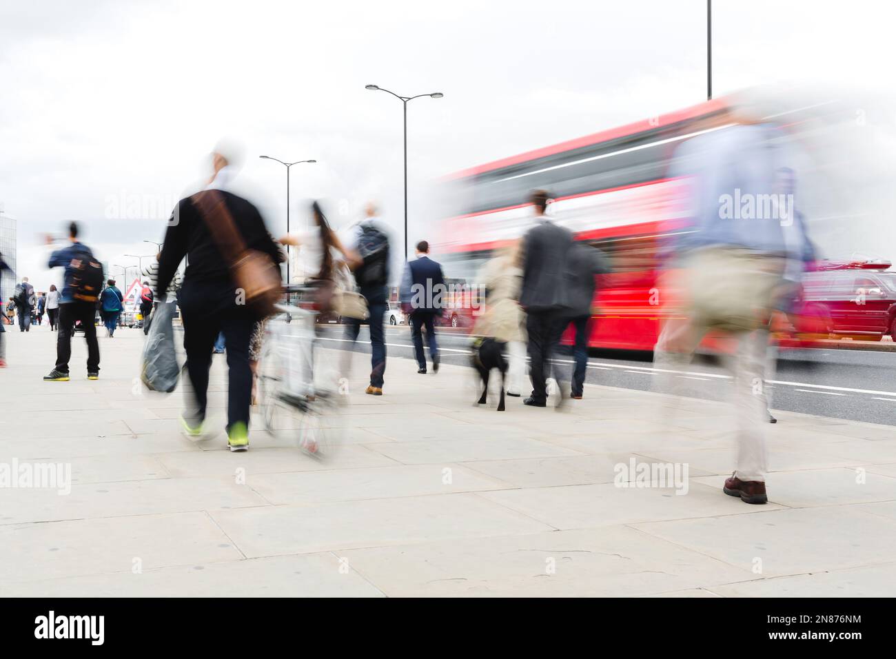 picture of crowds of commuters who are walking over a bridge in London ...