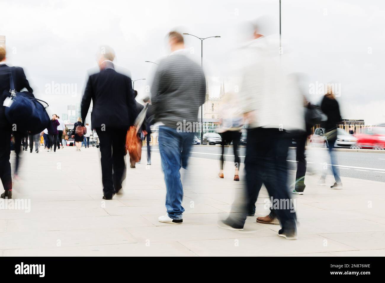 picture of crowds of commuters who are walking over a bridge in London ...