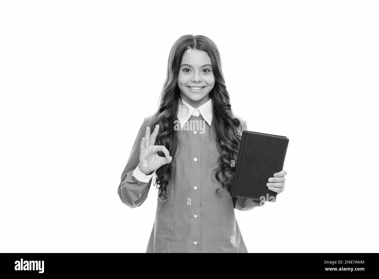 Happy primary school pupil hold library book showing OK sign isolated ...