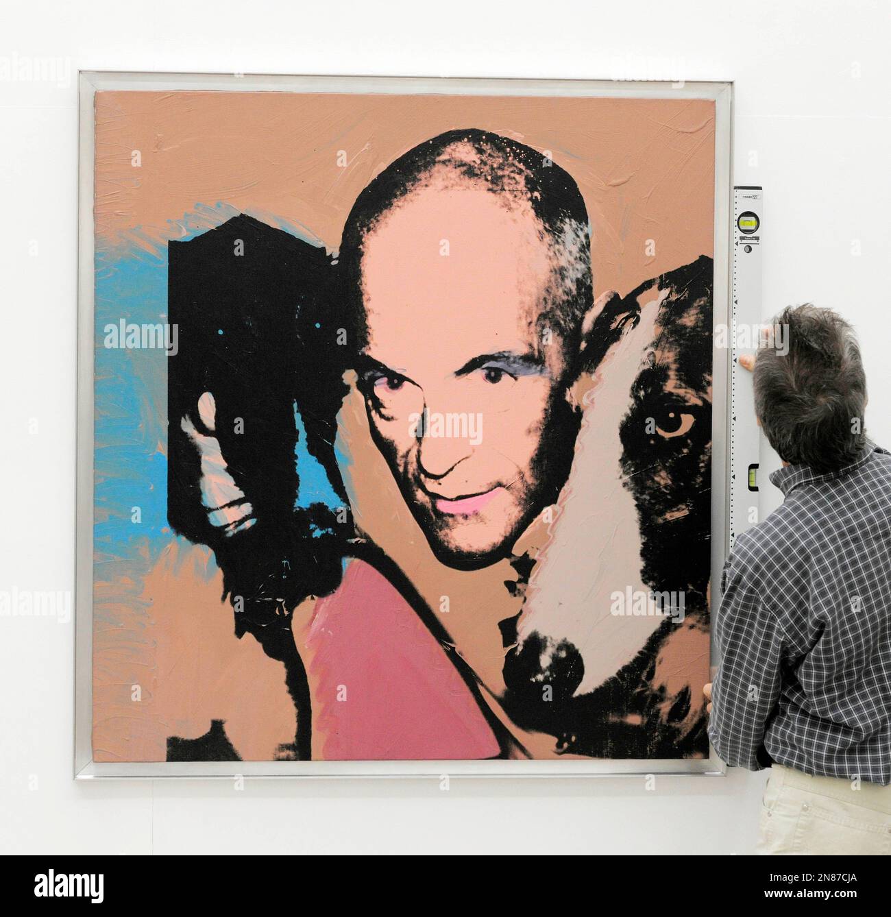 A worker fixes a portrait of Simon Spierer (1973) by Andy Warhol in the ...