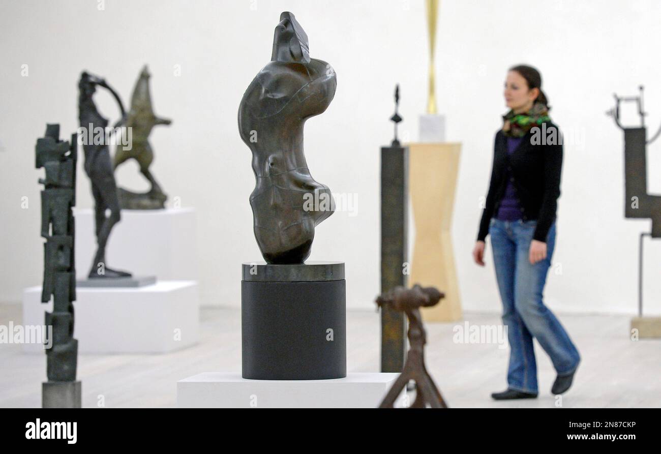 A woman walks between the sculptures during a preview in the exhibition ...