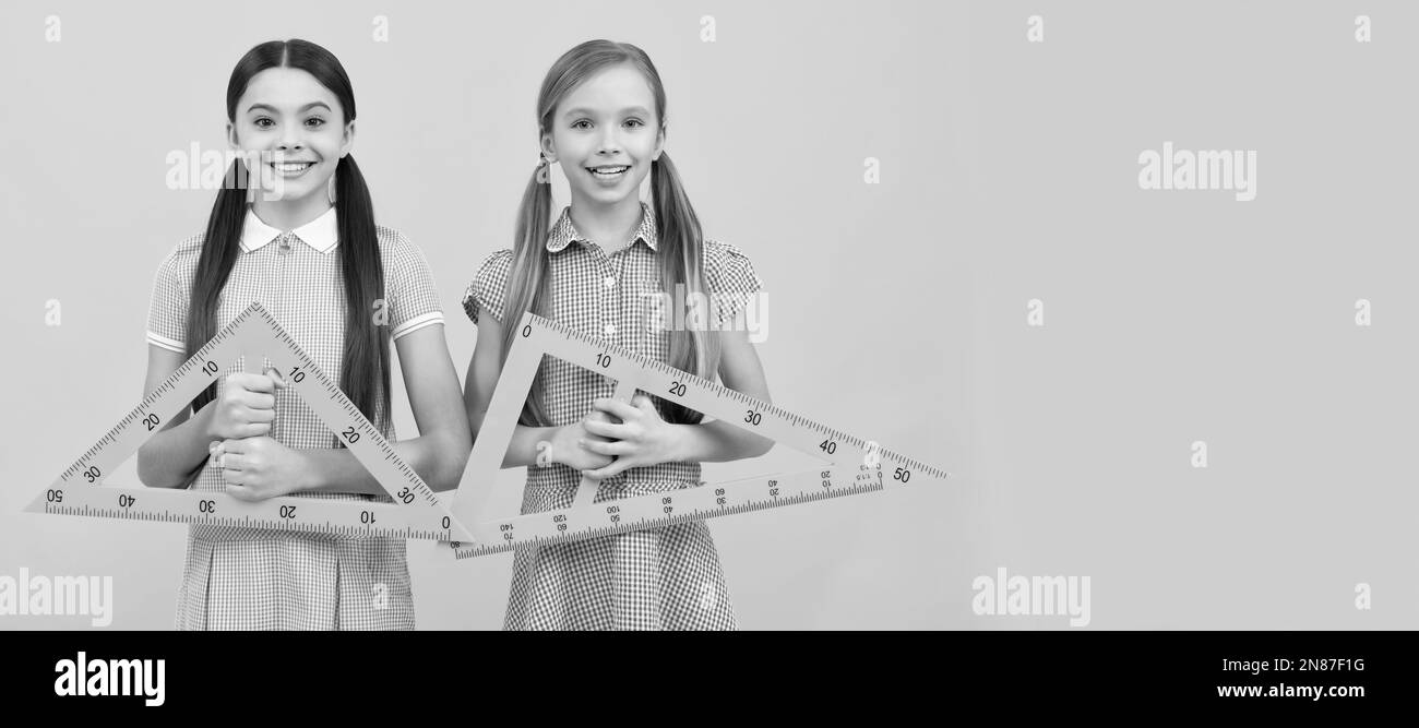 School girls friends. Happy kids hold triangular rulers. Geometry ...