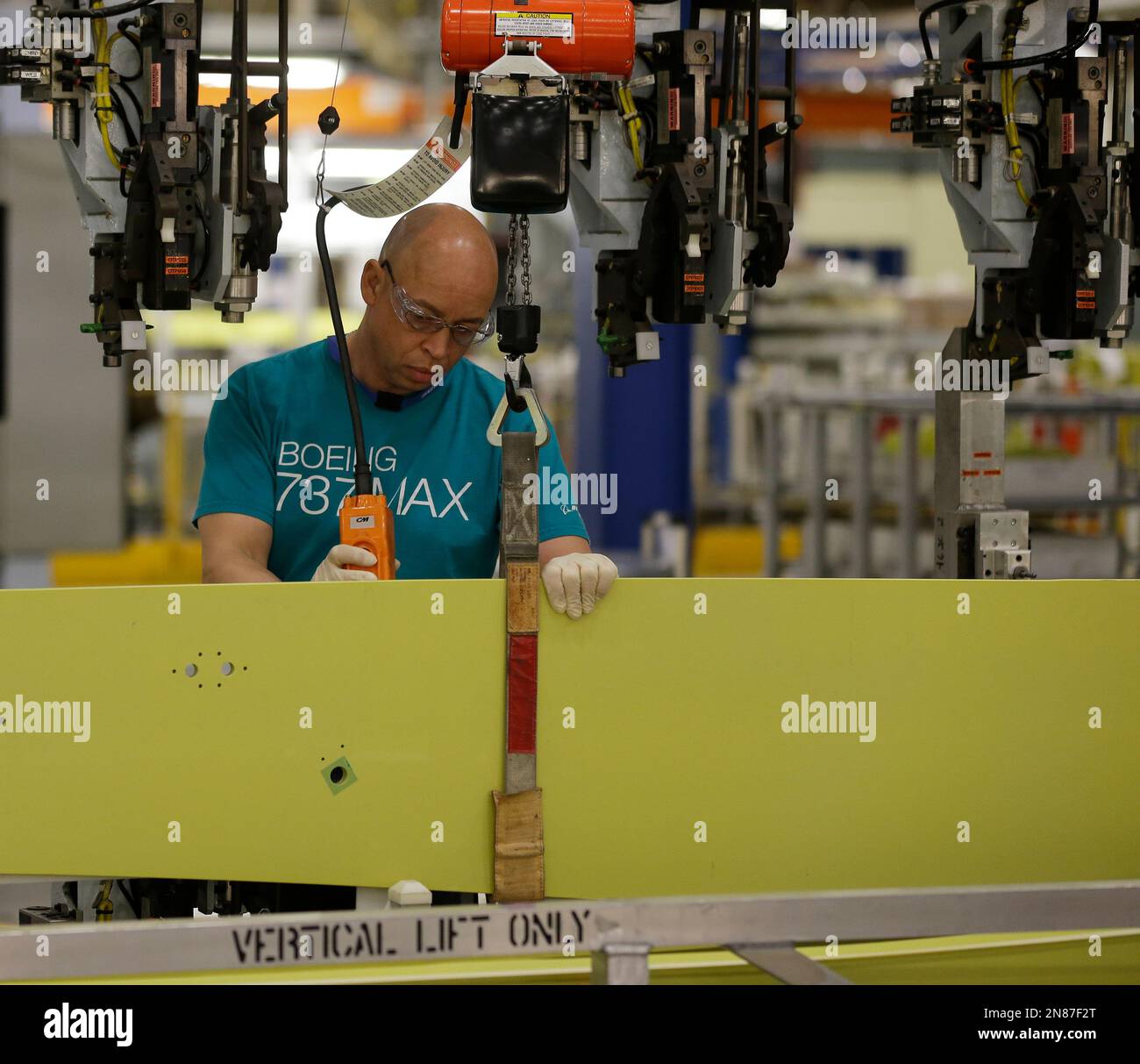 Boeing Co. worker Larry Freeman uses a hoist to help lift a wing spar ...