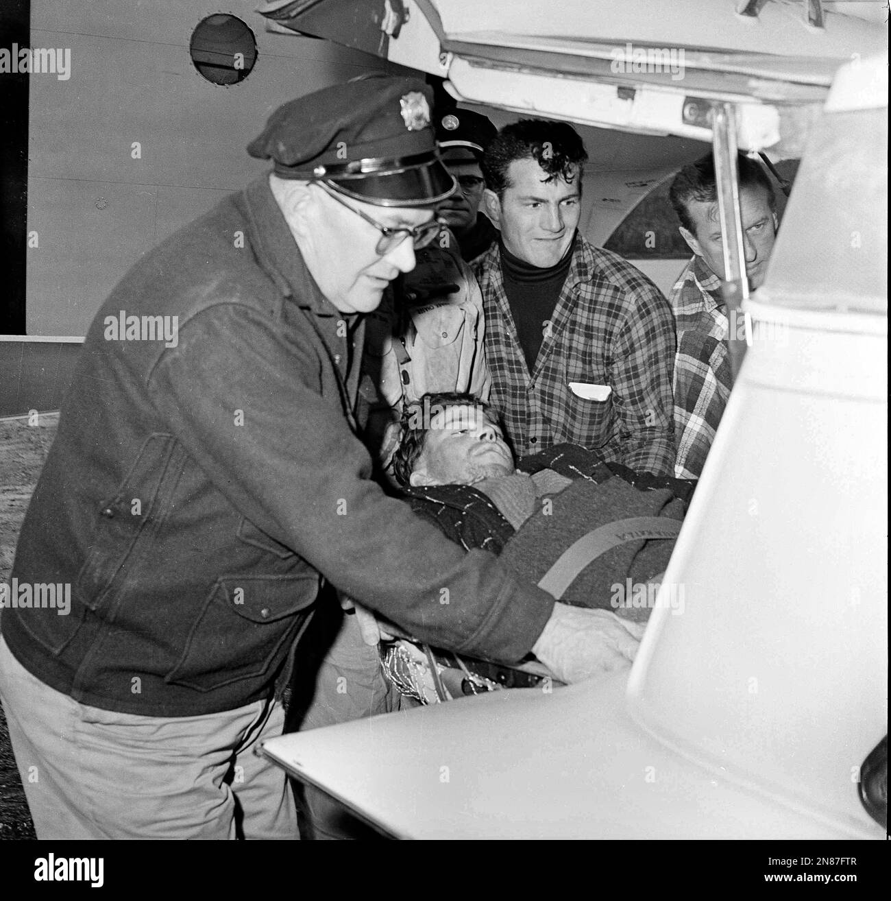 Rescue workers and a Coastguardsman lower a victim of the avalanche at ...