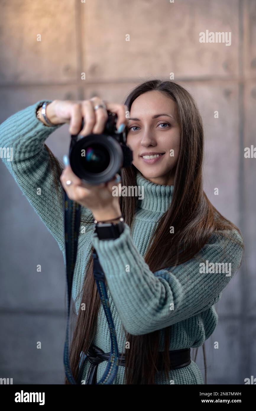 beautiful girl with a modern camera in her hands in a green dress ...