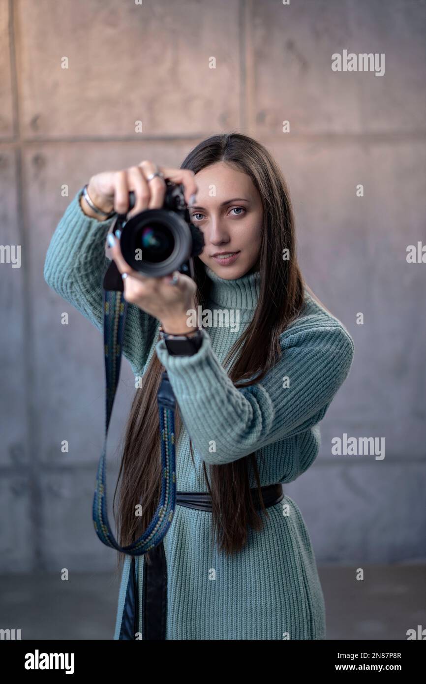 beautiful girl with a modern camera in her hands in a green dress ...